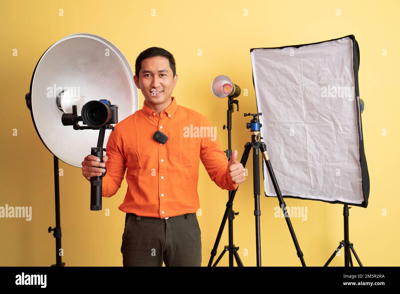 vlogger standing with thumbs up and holding camera with stabilizer ...