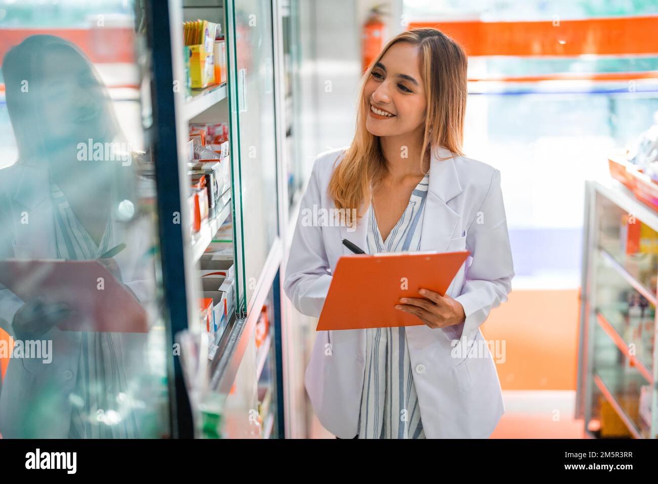 female pharmacist in uniform at work checking medicine Stock Photo - Alamy