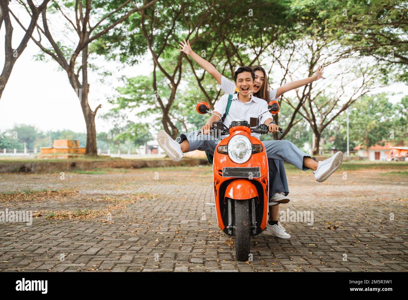 Couple of high school students having fun riding a motorbike Stock ...