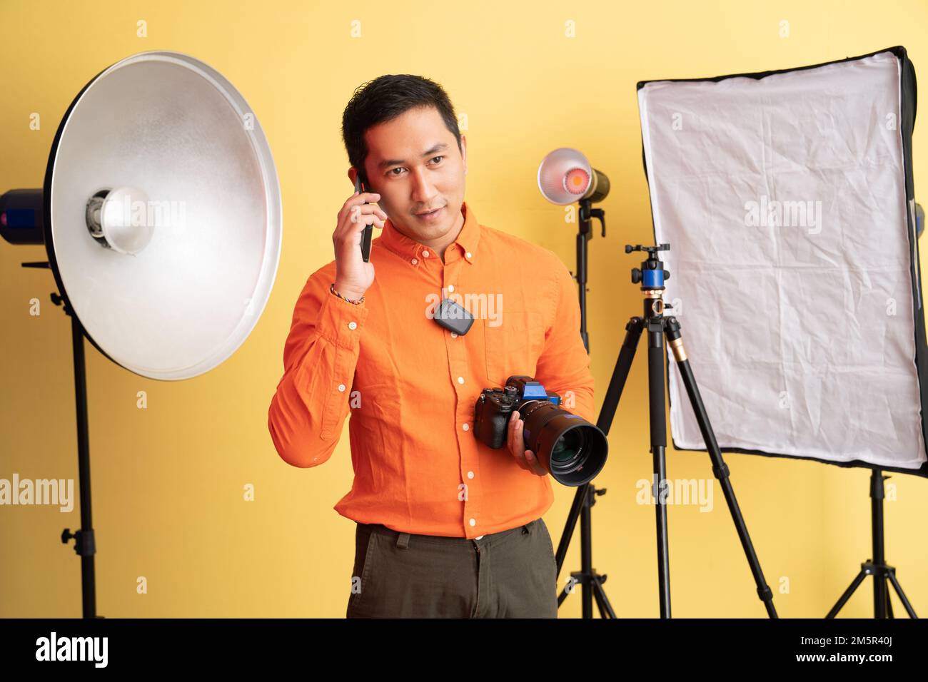 photographer holding professional camera while making phone call Stock ...