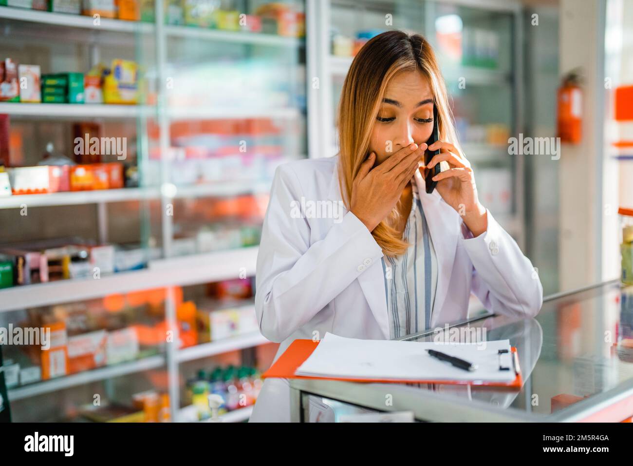 female pharmacist shocked when she received a call while working Stock ...