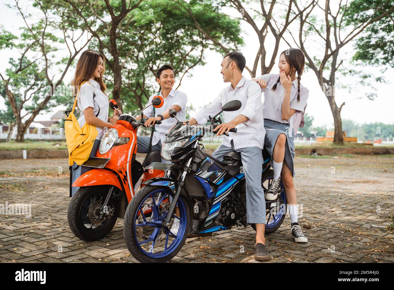 Asian high school students chatting on a motorbike Stock Photo - Alamy