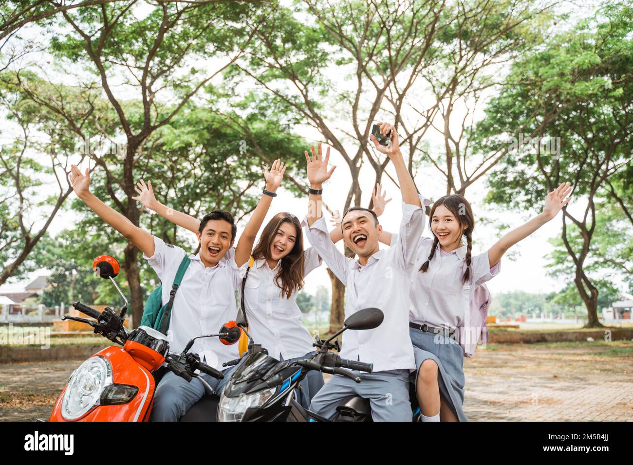 high school students celebrating graduation while sitting on a ...