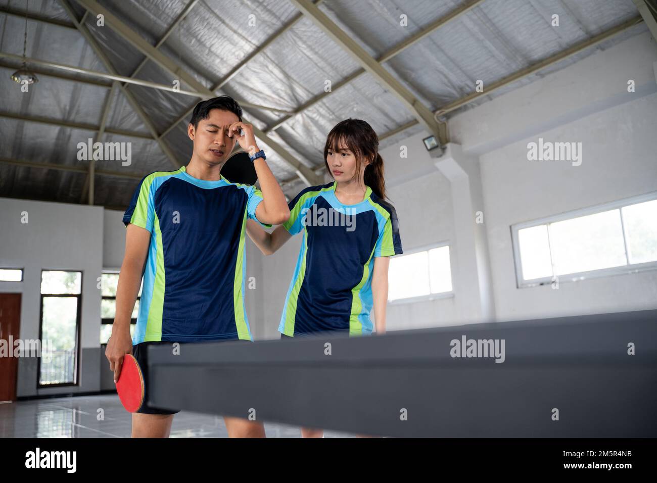Asian male and female ping pong players are sad Stock Photo - Alamy