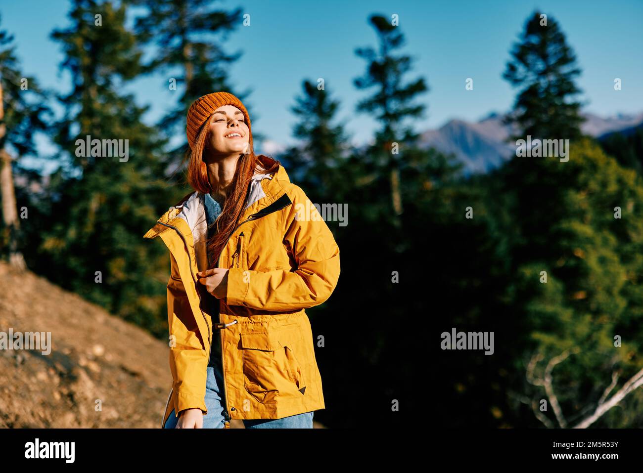 Woman red hair on a hike in the mountains walking a smile and look at ...