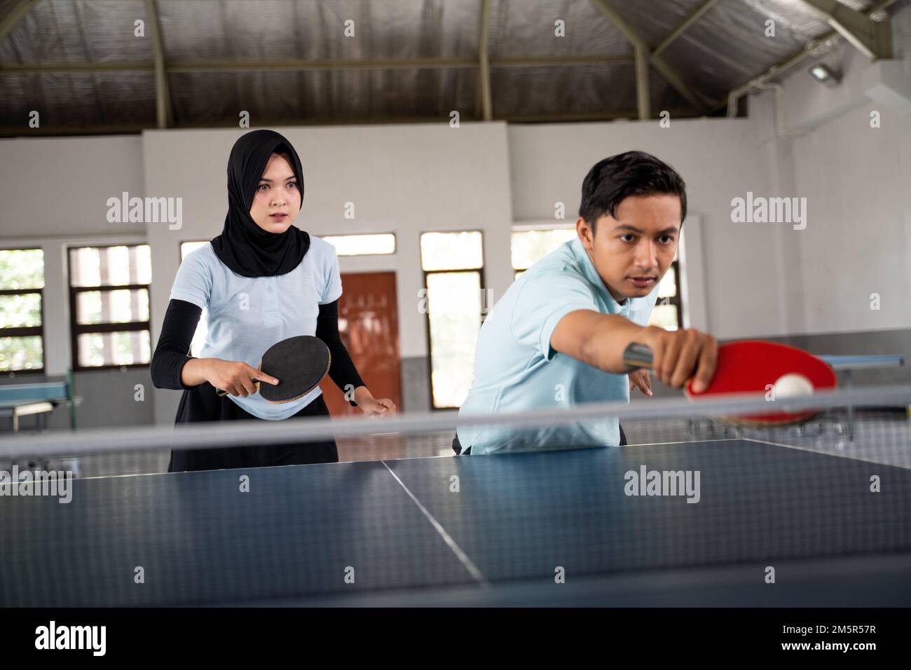 male ping pong athlete hitting the ball over the net Stock Photo - Alamy