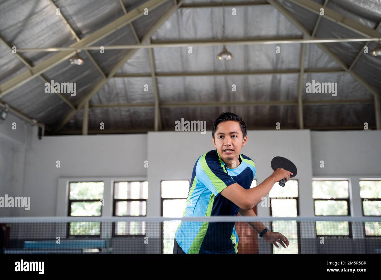 male athlete backhand hitting in a ping pong match Stock Photo - Alamy