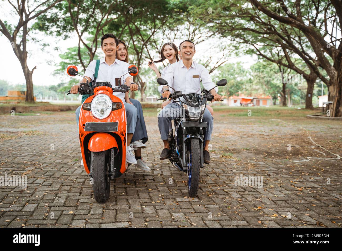 Four Asian high school students in uniform riding a motorbike Stock ...
