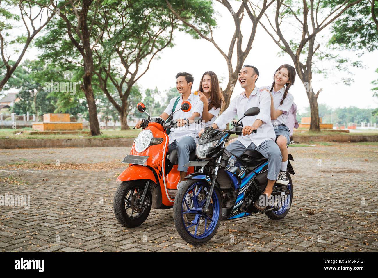 High school student riding motorbike without helmet on park road Stock ...