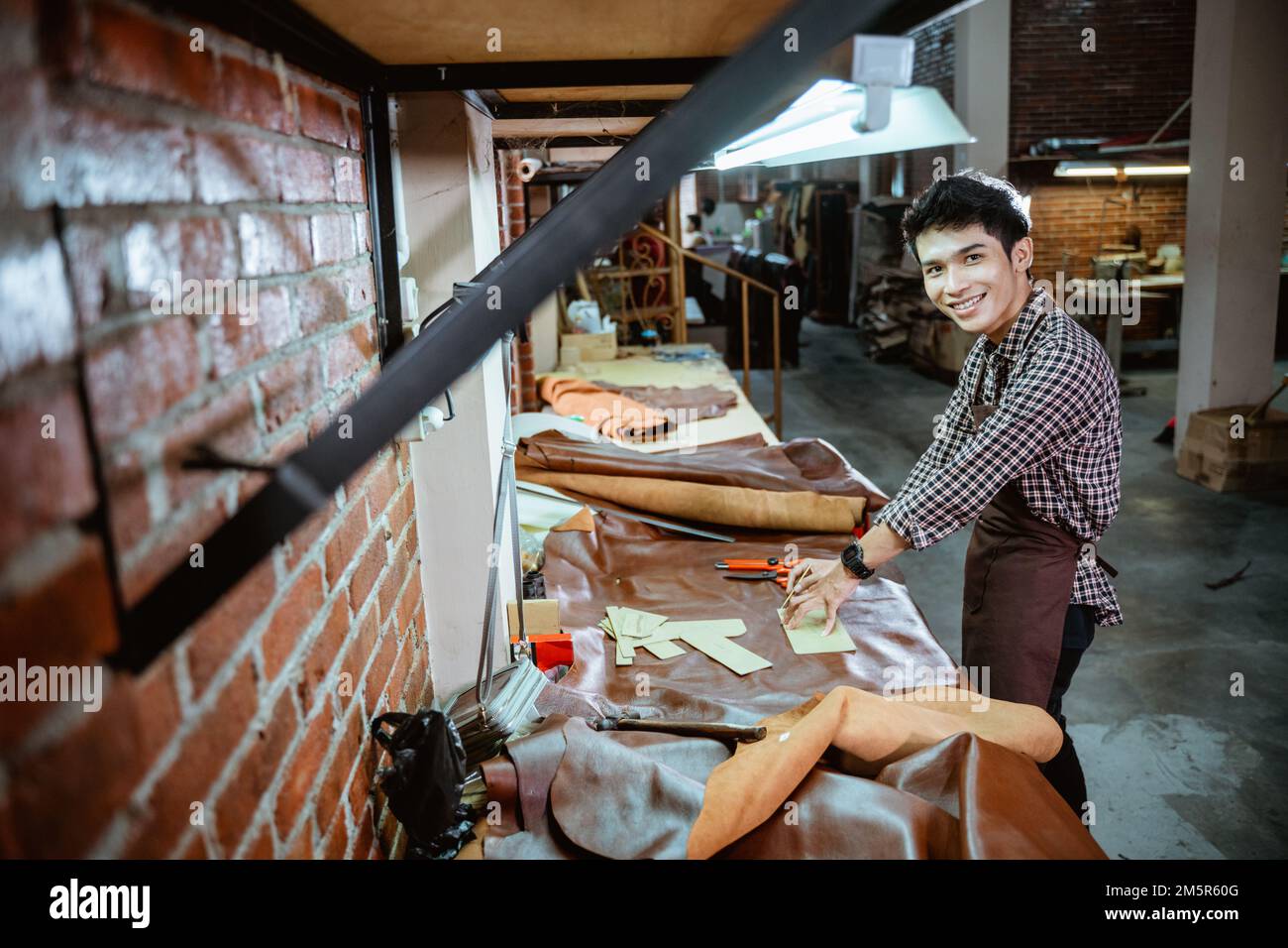 Young Asian male skin worker smiling in his studio Stock Photo - Alamy
