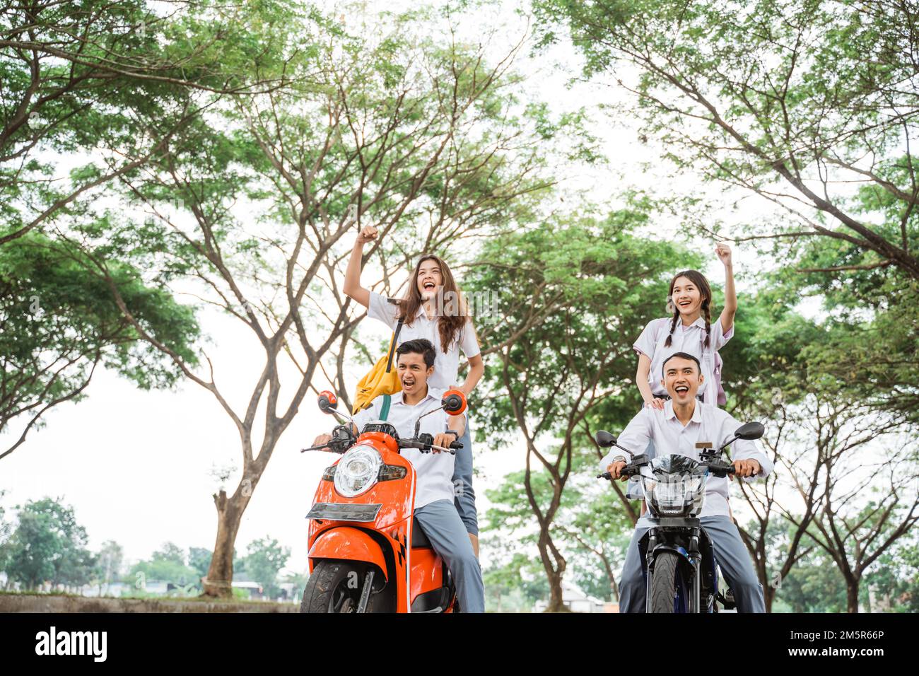 Two pairs of high school students riding reckless motorbikes Stock ...
