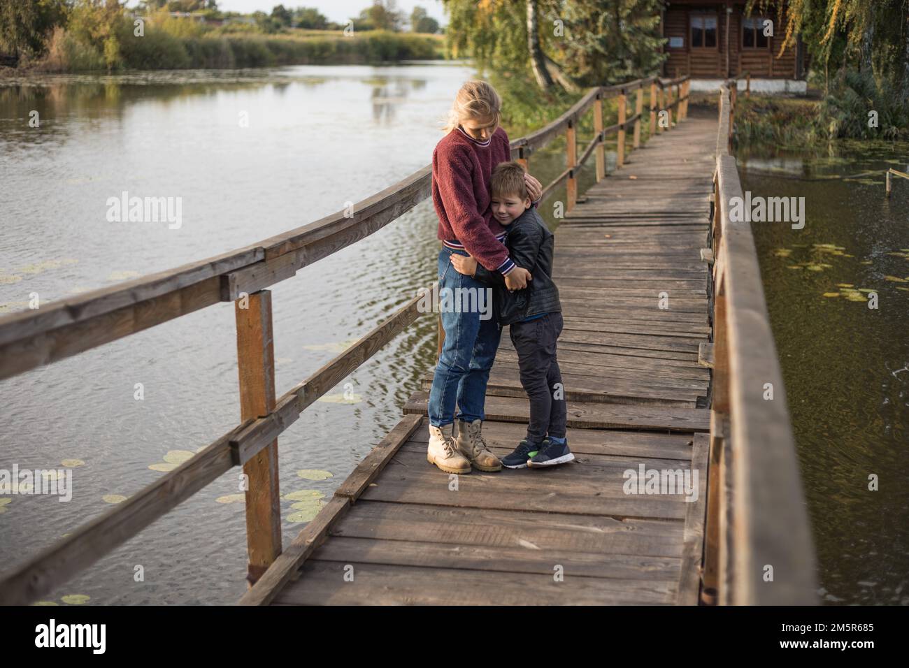 Upset young mother give comforting hug to crying little son. Handsome ...
