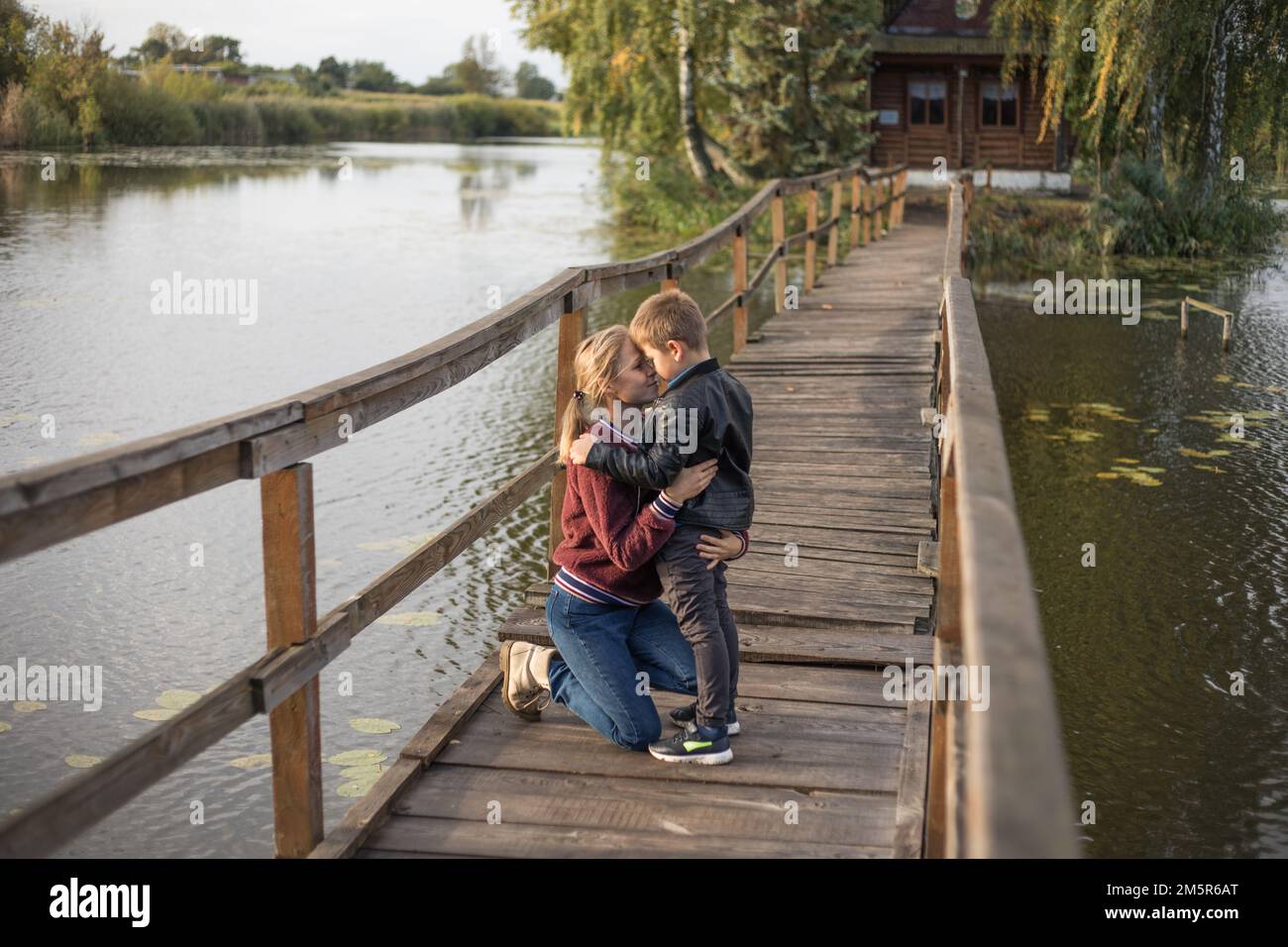 Upset young mother give comforting hug to crying little son. Handsome ...