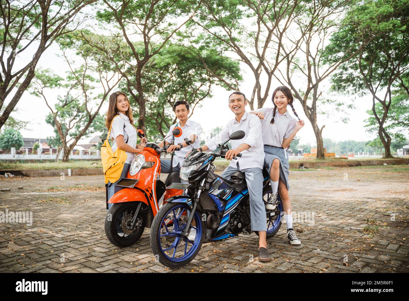 Asian high school students looking at the camera on motorbike Stock ...