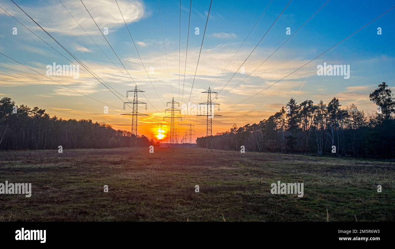 Power poles photographed backlit at sunset in rural area with clear ...
