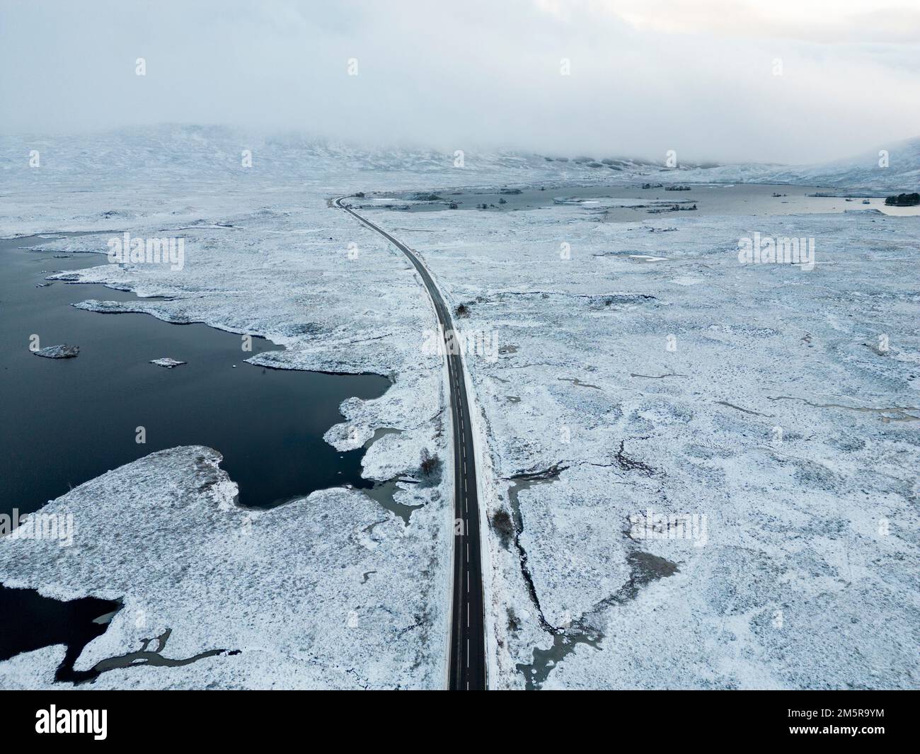 Aerial view of road crossing Rannoch Moor in winter snow, Scottish ...