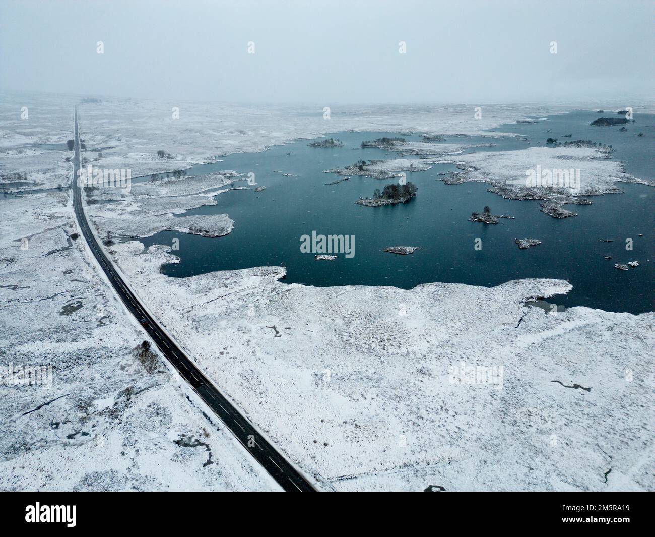 Aerial view of road crossing Rannoch Moor in winter snow, Scottish ...