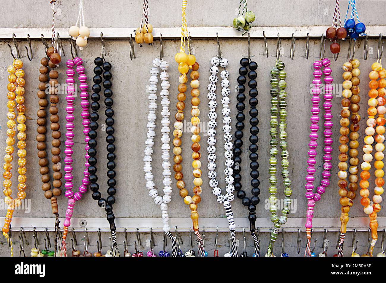 Many rosaries in various colors and materials are exposed at the shop ...