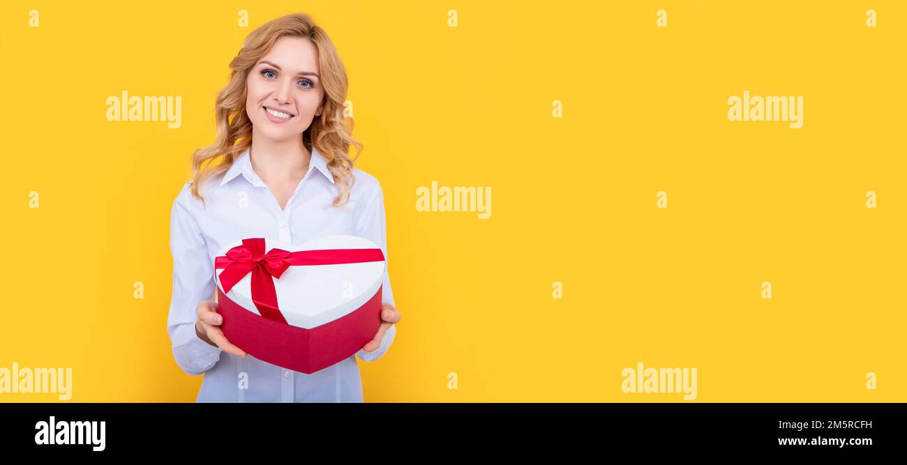 happy woman hold present heart box on yellow background. Woman isolated ...