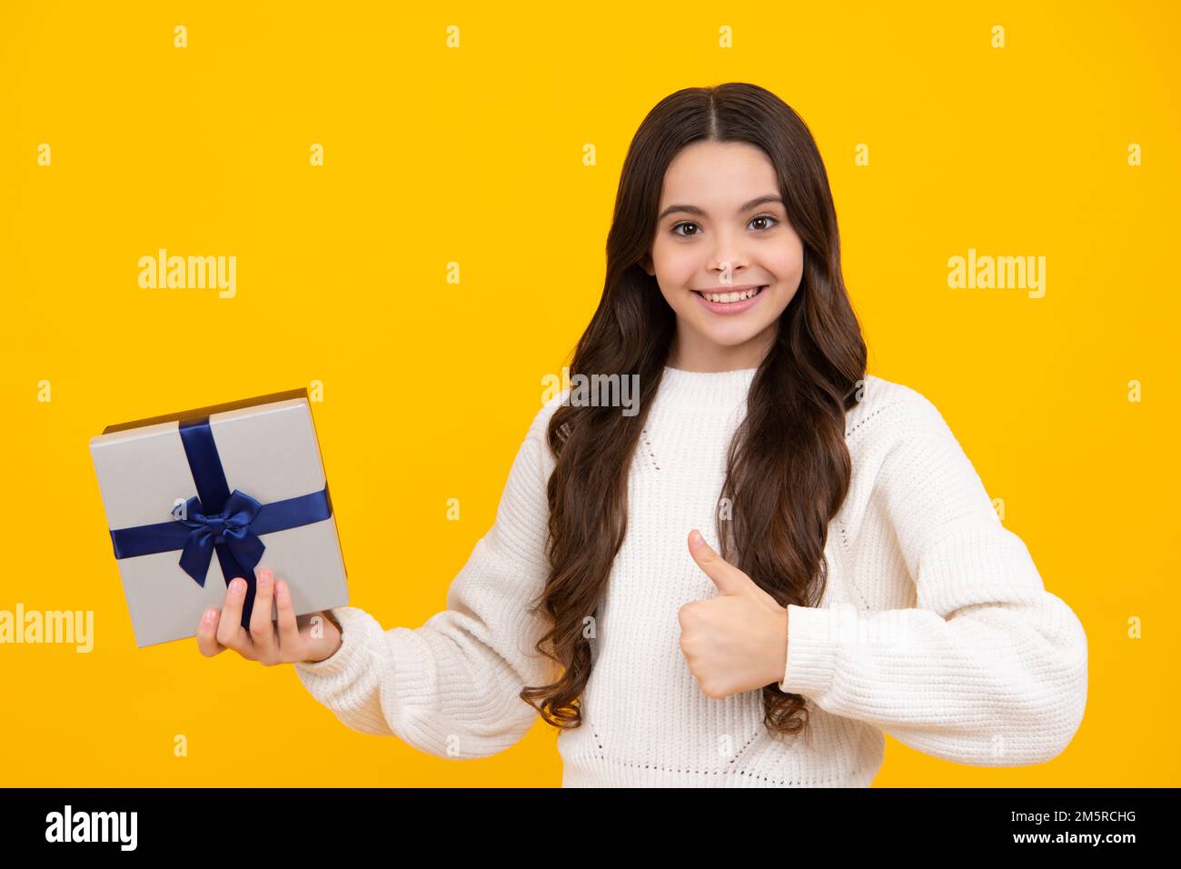 Child with gift present box on isolated studio background. Gifting for ...