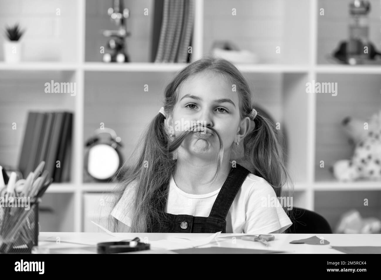 cute kid having fun with long hair pony tail at school lesson in ...