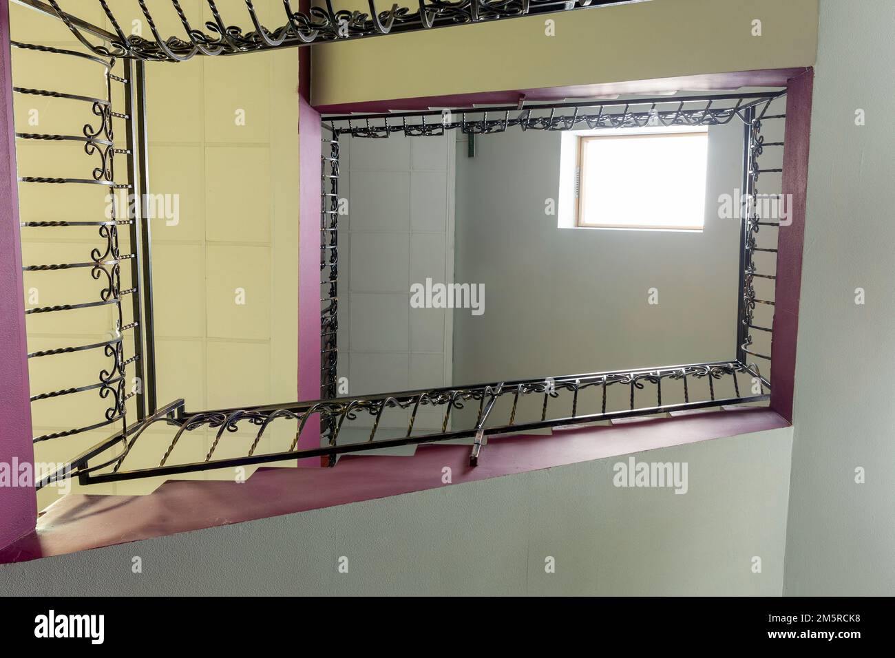 Looking up a three story staircase in modern building. Spiral staircase ...