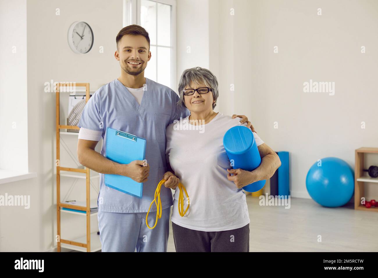 Portrait of happy physiotherapist and senior patient standing in physiotherapy room Stock Photo ...
