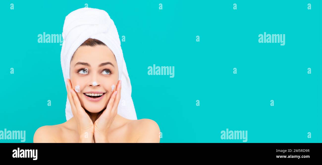 Skin care beauty woman. amazed young lady applying face cream on blue background. Beautiful ...
