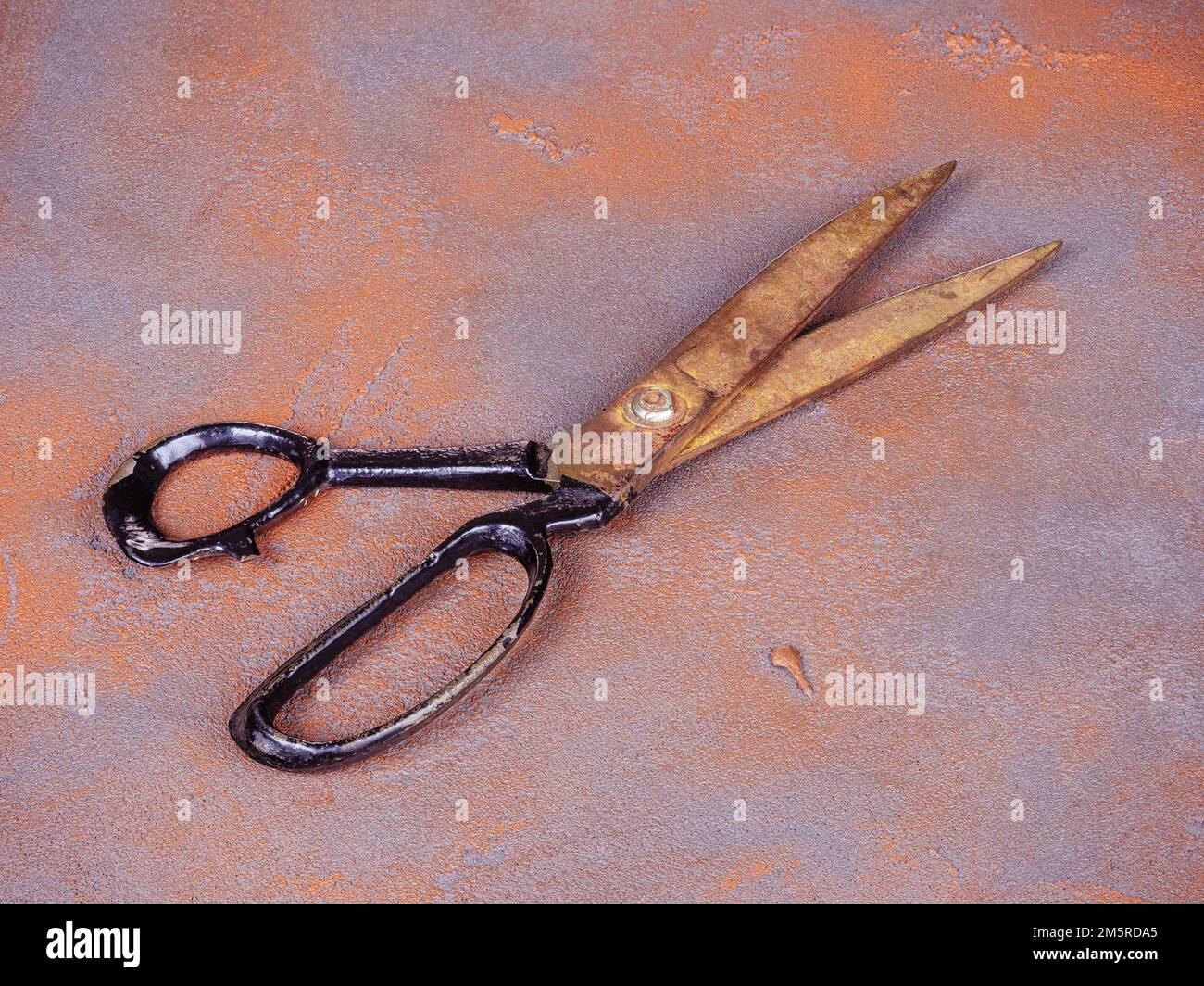 Old rusty scissors on a grunge orange background Stock Photo - Alamy