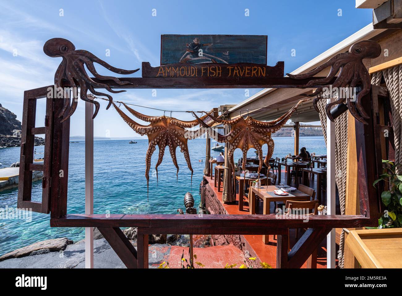 Two octopuses hanging near the entrance of a fish tavern on Ammoudi Bay ...