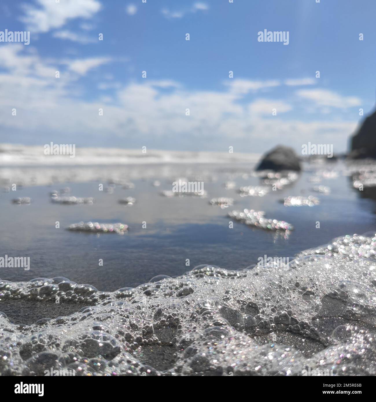 A scenic view of a sea shore with calm waves during daytime on a blurry ...