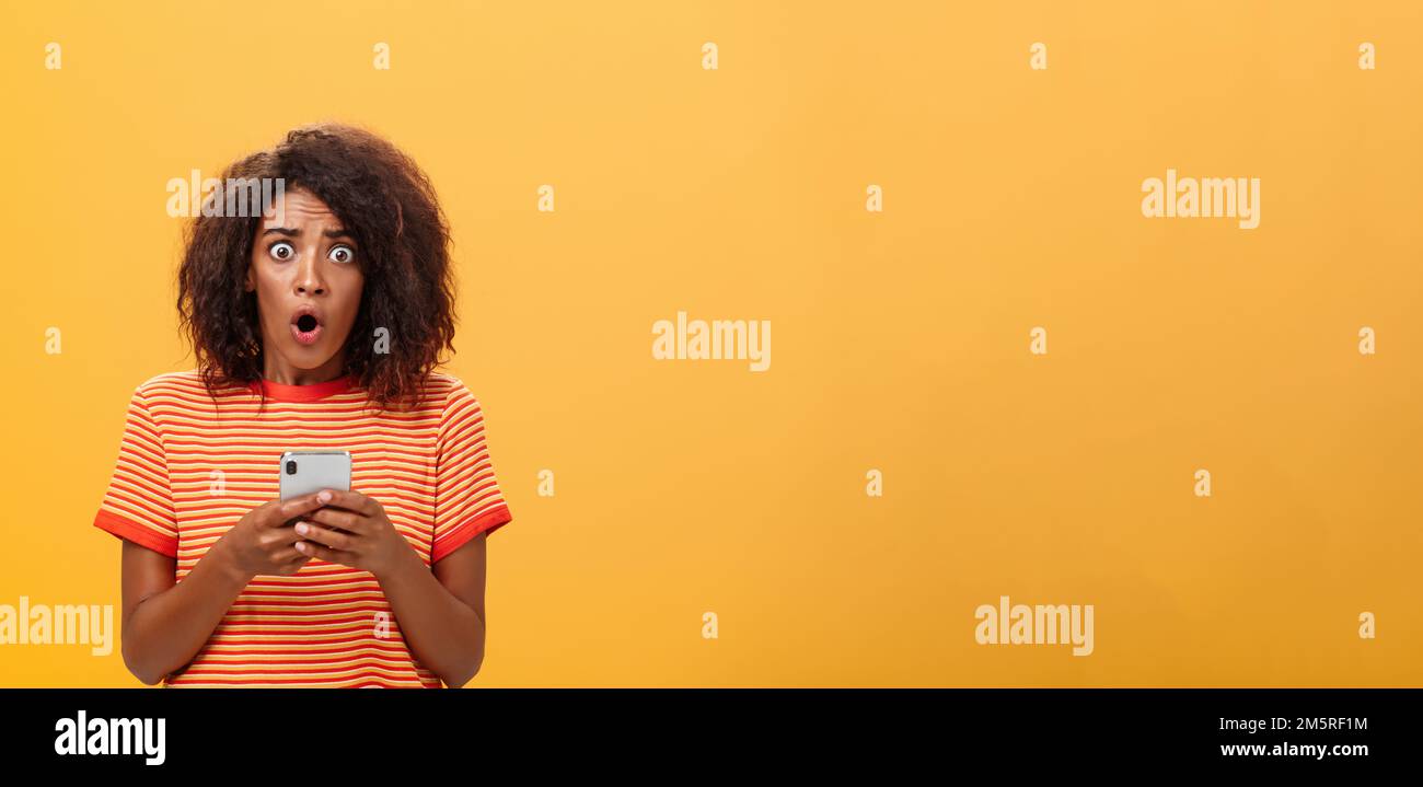 Portrait of shocked and concerned stunned dark-skinned woman with afro ...