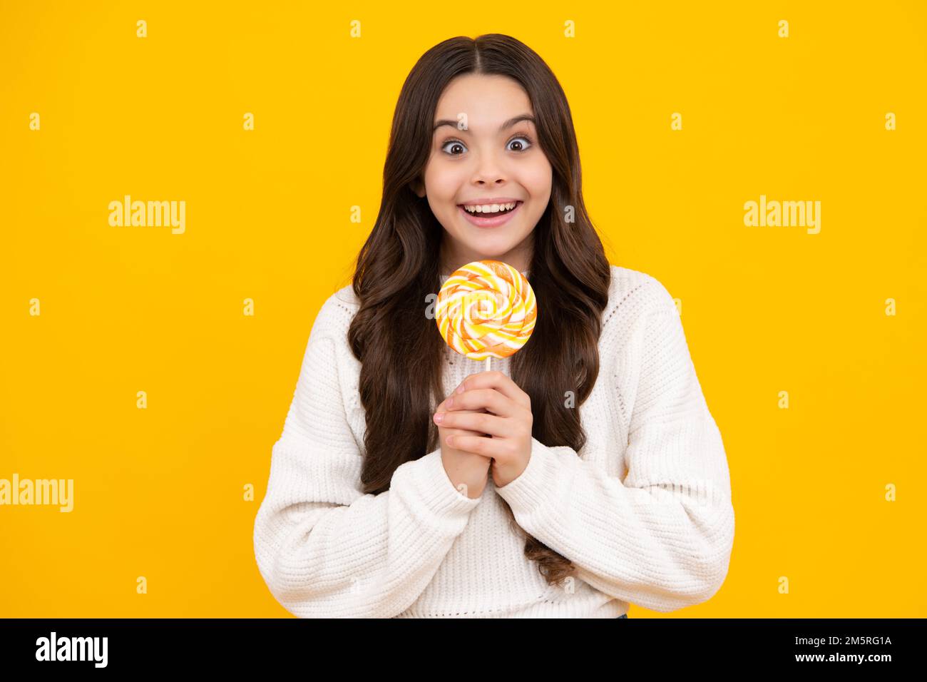Cool teen child with lollipop over yellow isolated background. Sweet ...