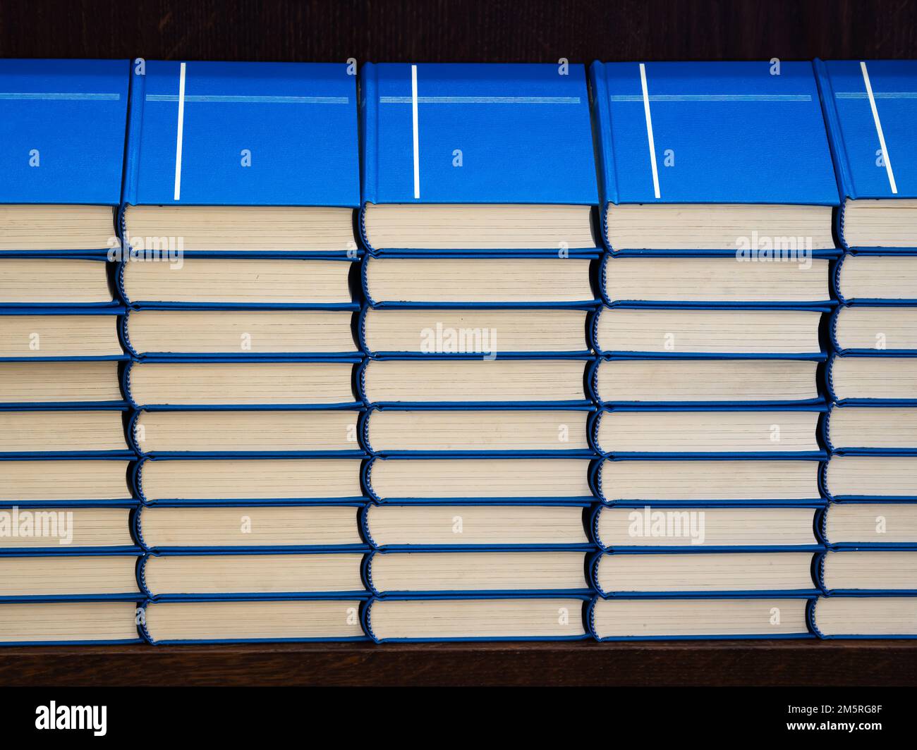A stack of identical church books with blue covers with cross on a ...
