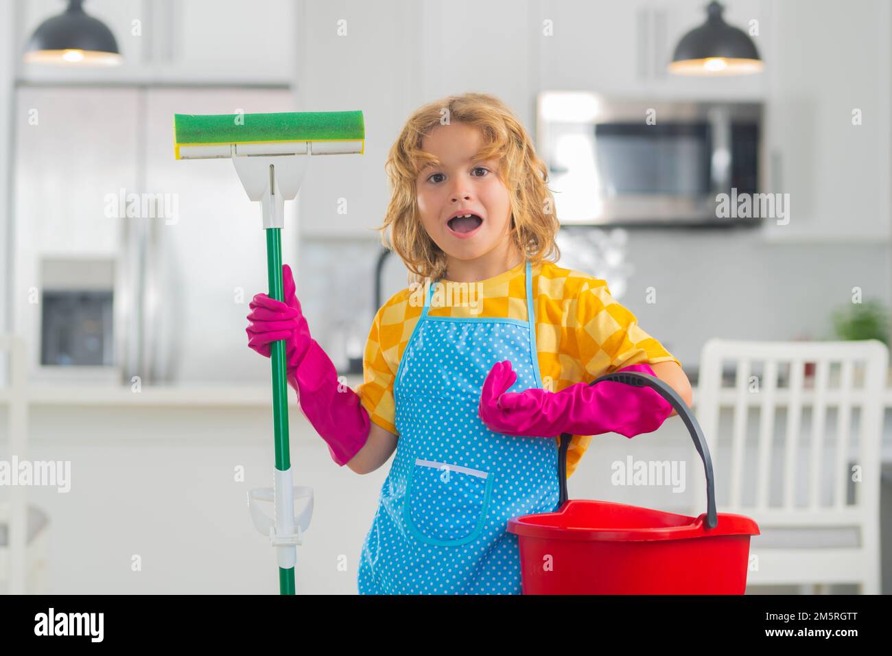 Child cleans at home concept. Kid cleaning with mop to help with ...