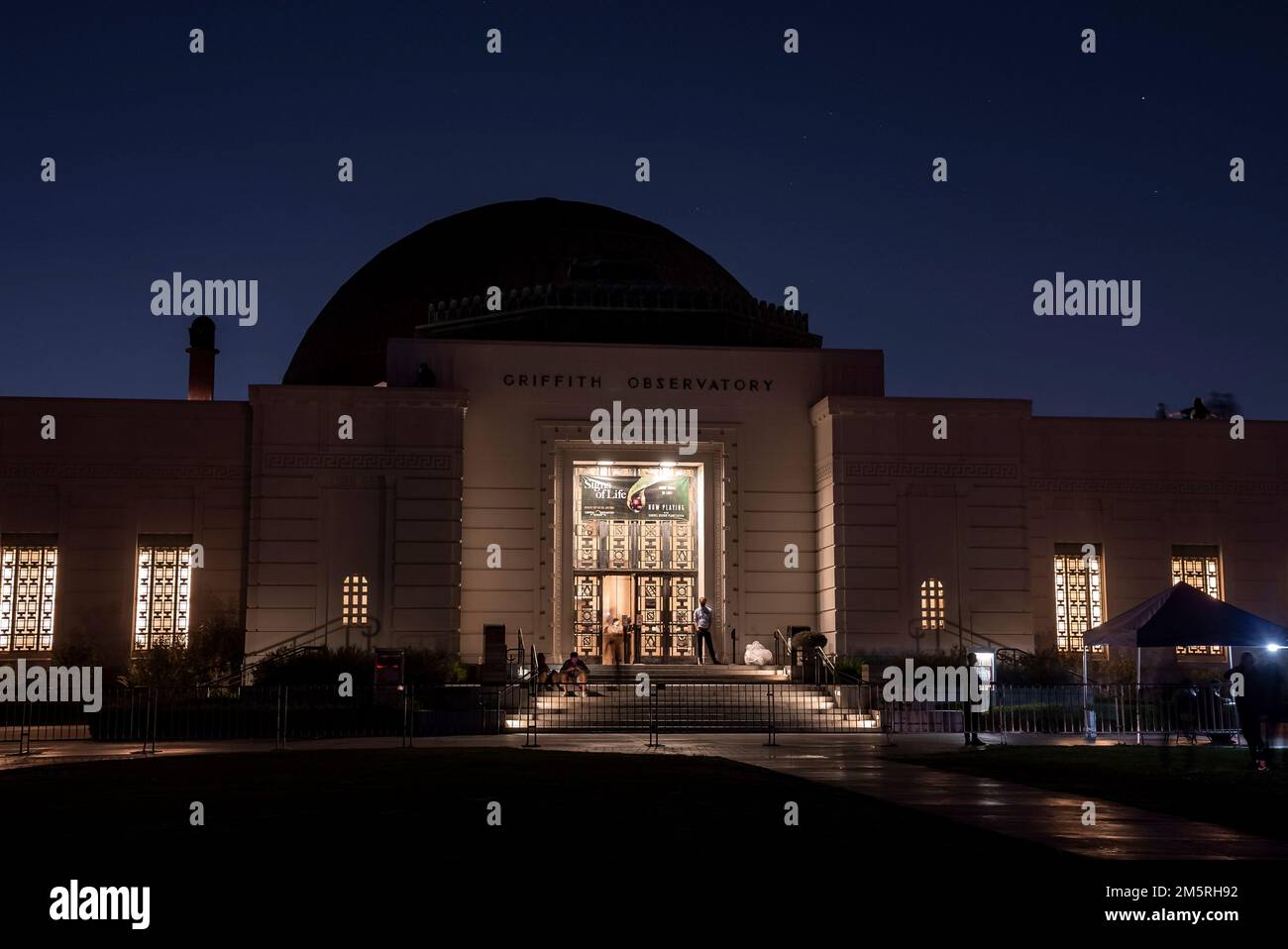 Entrance of illuminated Griffith Observatory with blue sky at night ...