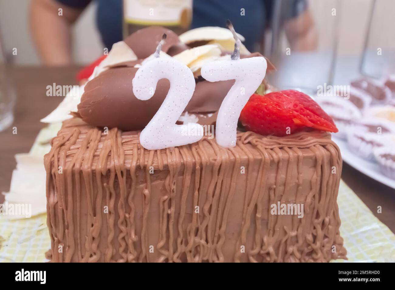 Birthday cake with candles in the shape of number 27 on a table mounted ...