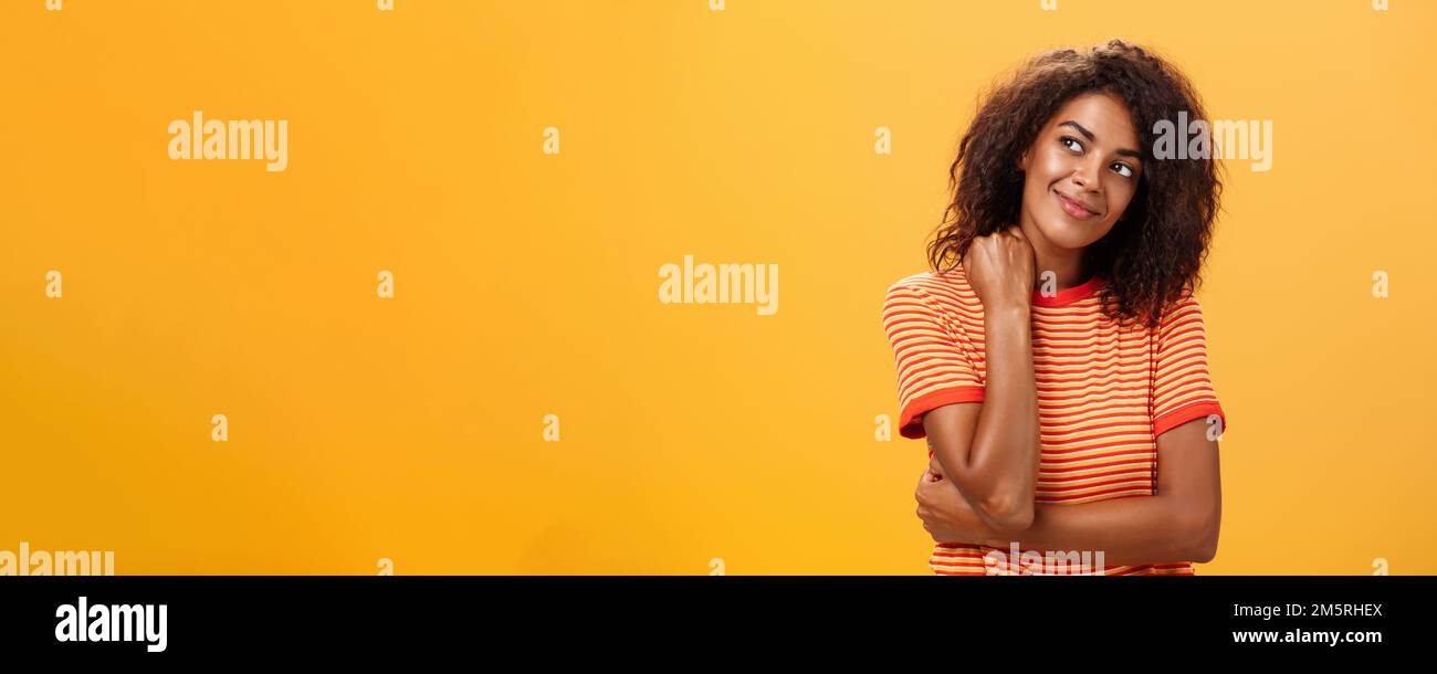 Cute and gentle dreamy dark-skinned girl with cruly hairstyle tilting ...