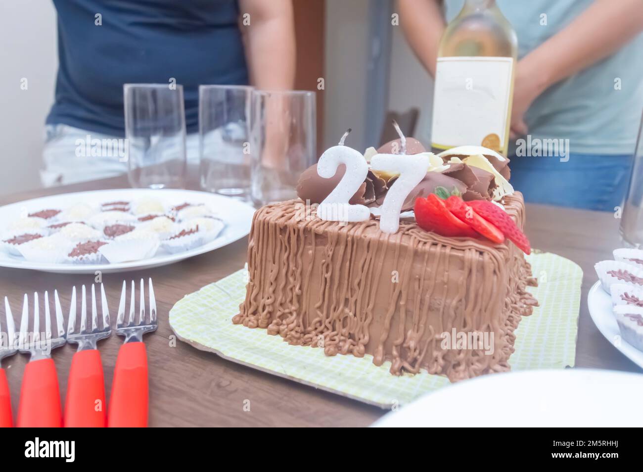 Birthday cake with candles in the shape of number 27 on a table mounted ...