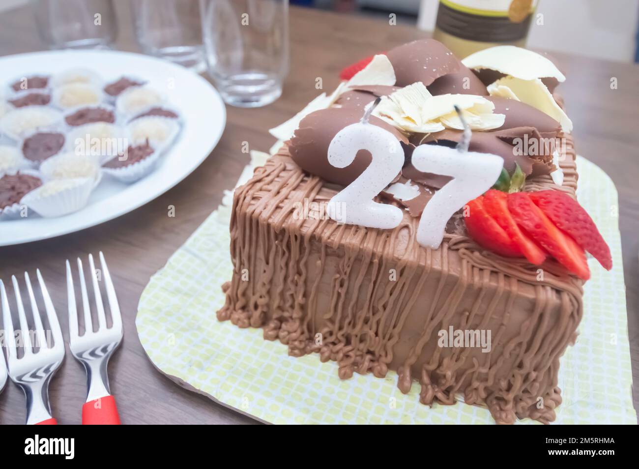 Birthday cake with candles in the shape of number 27 on a table mounted ...