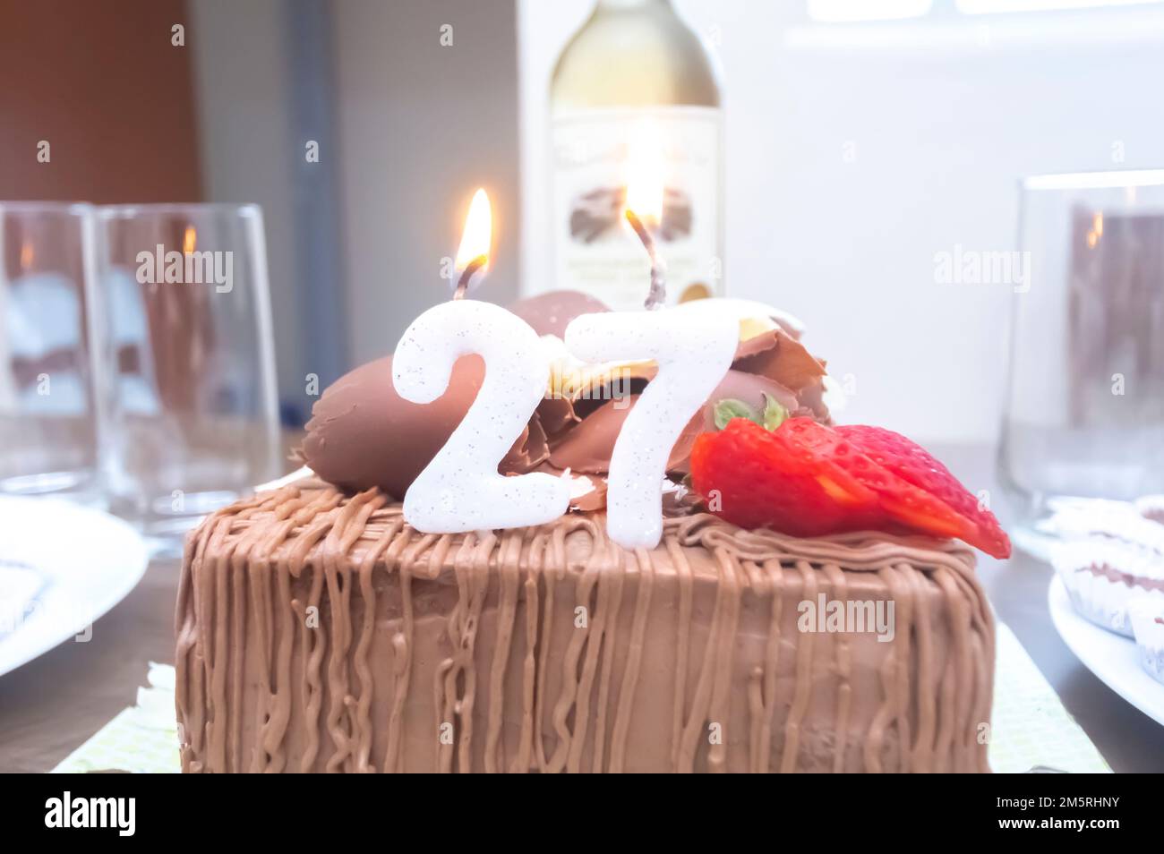 Birthday cake with candles in the shape of number 27 on a table mounted ...