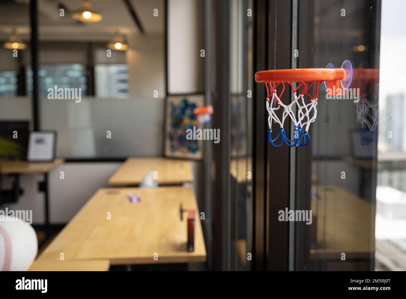 A mini basketball basket attached on the office window at WeWork ...