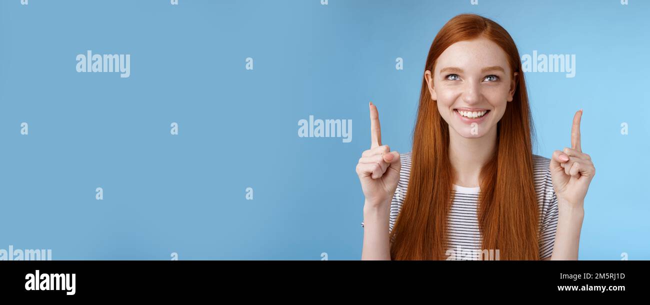 Amused excited happy smiling redhead girl look pointing up grinning ...
