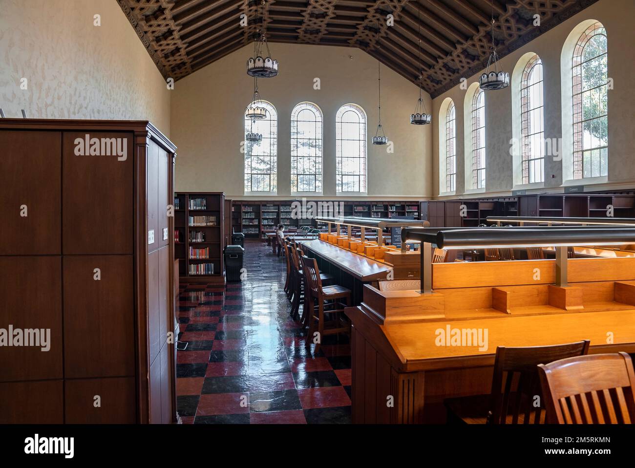 Chandeliers hanging from ceiling over furniture arranged in UCLA library Stock Photo - Alamy