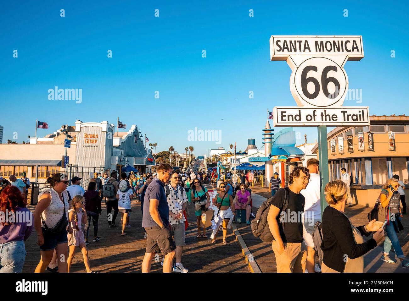 People walking by Santa Monica 66 end of the trail road sign during ...