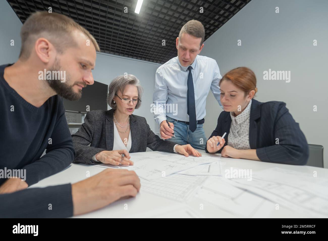 The boss gives instructions to three employees in the office conference ...