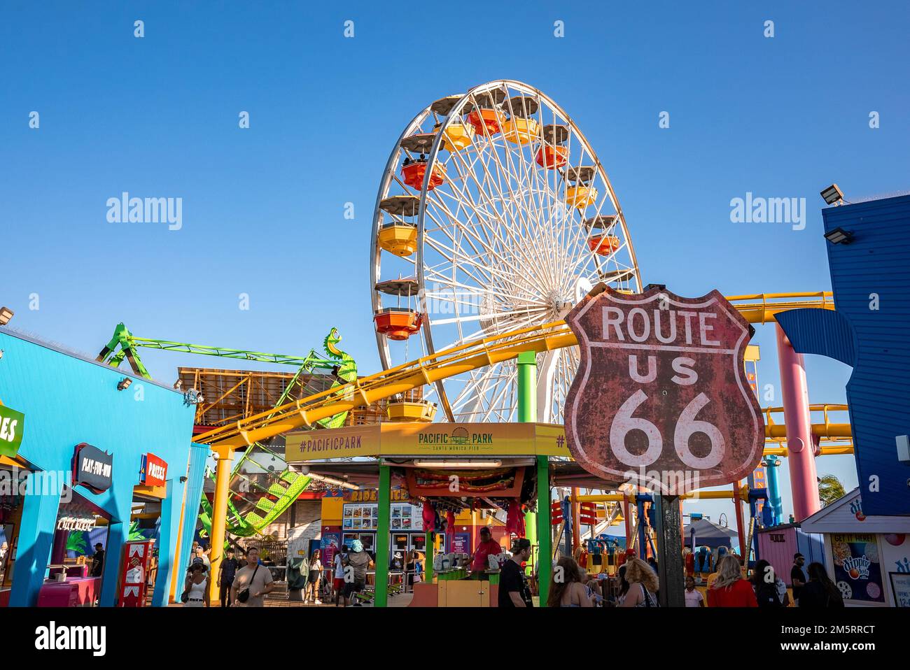 Ferris wheel and roller coaster seen through Route 66 road sign at ...