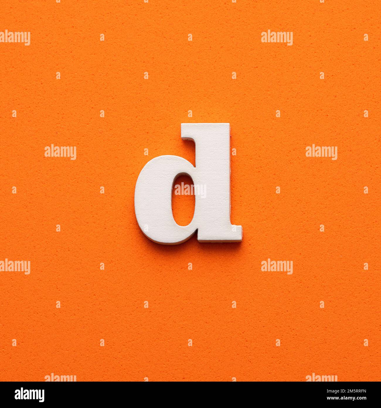 d white lowercase letter - Background in orange foamy Stock Photo - Alamy