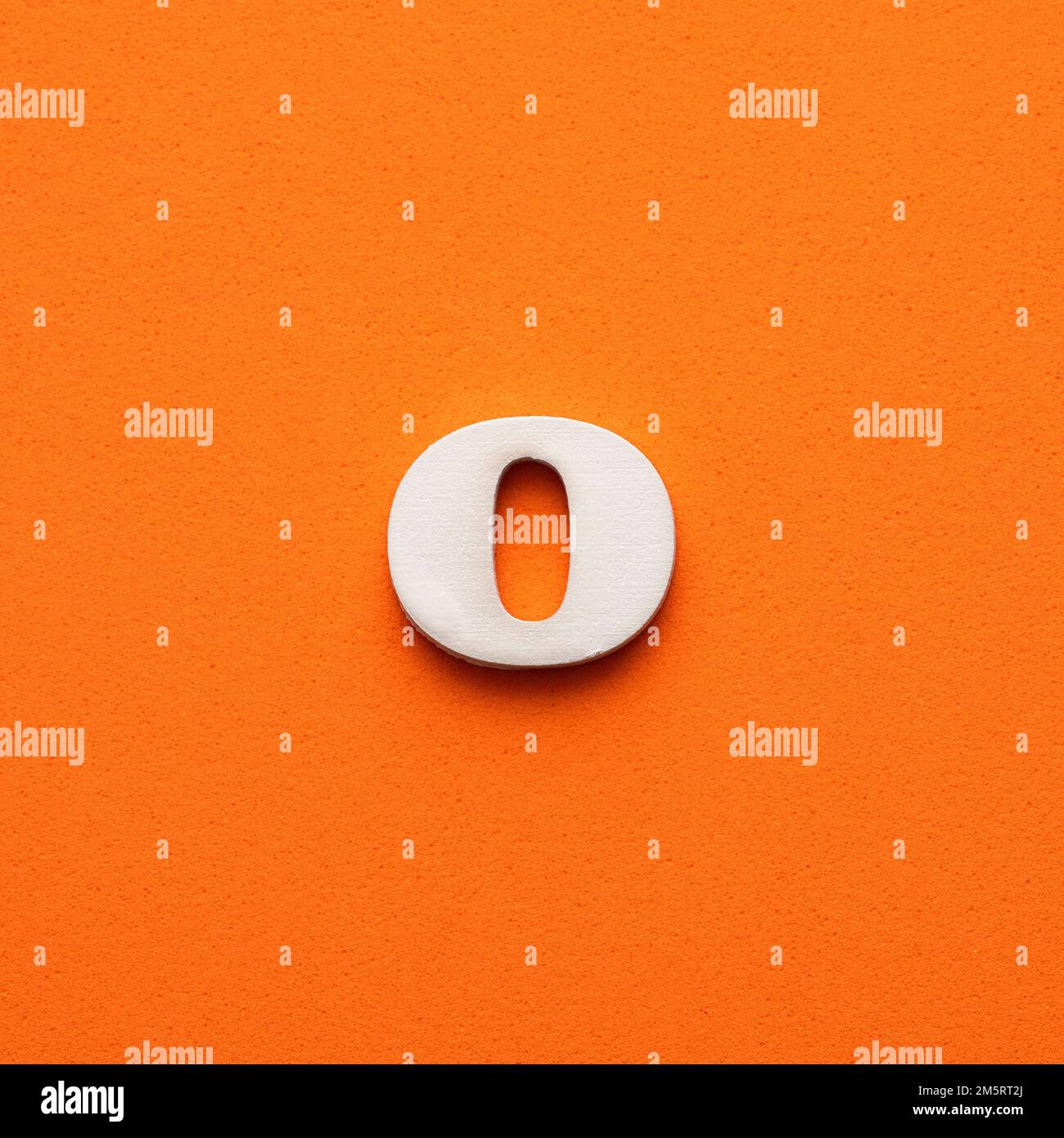 o white lowercase letter - Background in orange foamy Stock Photo - Alamy