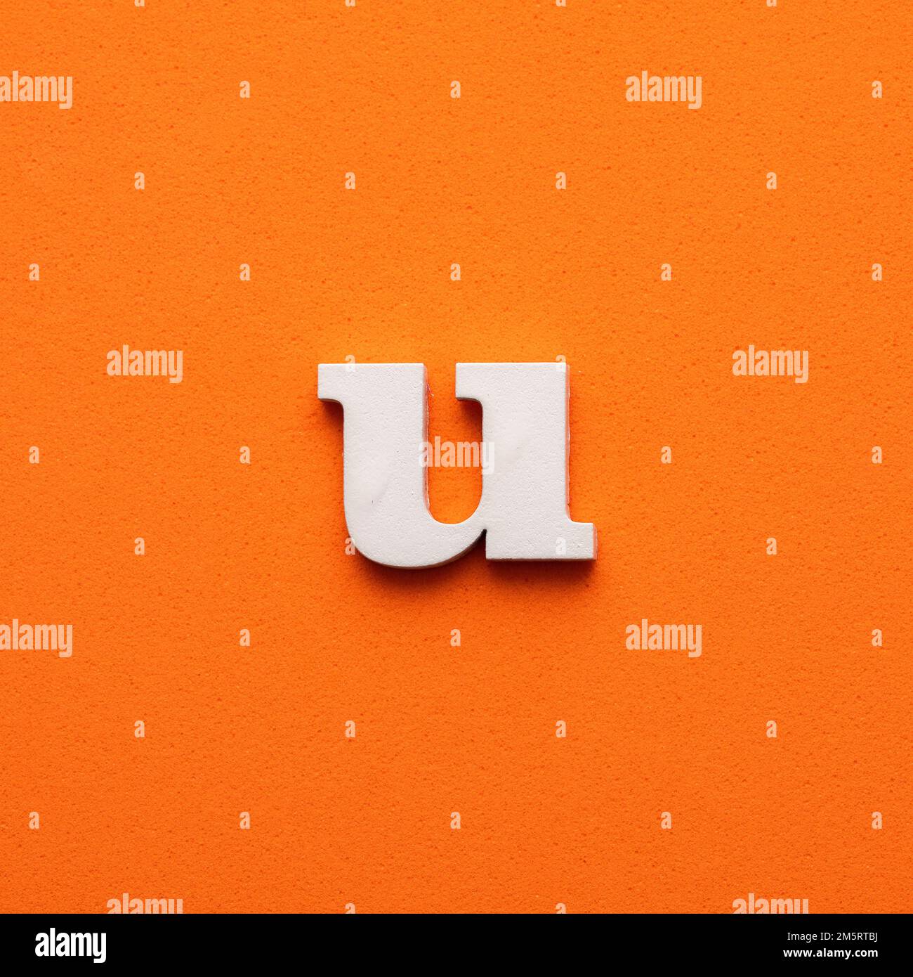u white lowercase letter - Background in orange foamy Stock Photo - Alamy